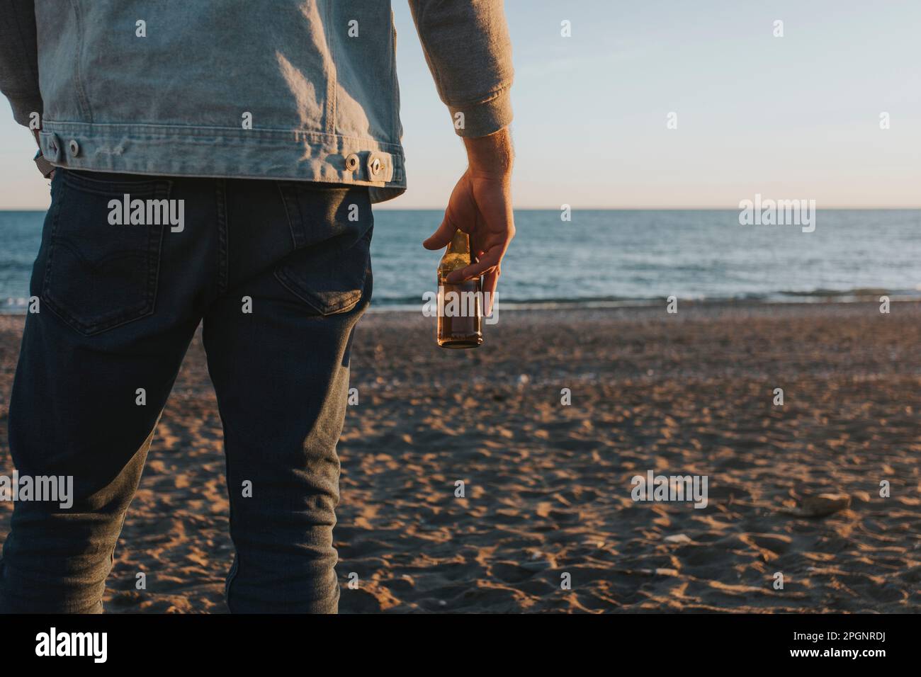 Hand of man standing with beer at beach Stock Photo - Alamy