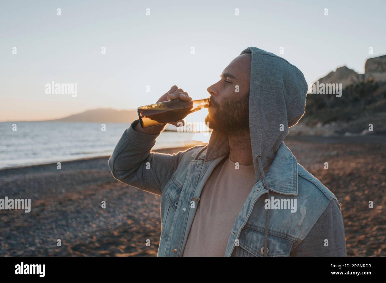 Man drinking beer at beach Stock Photo - Alamy