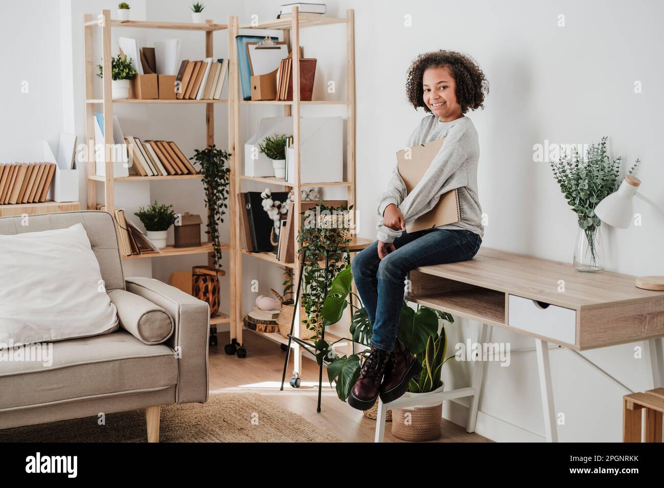 Girl sitting on desk hi-res stock photography and images - Alamy