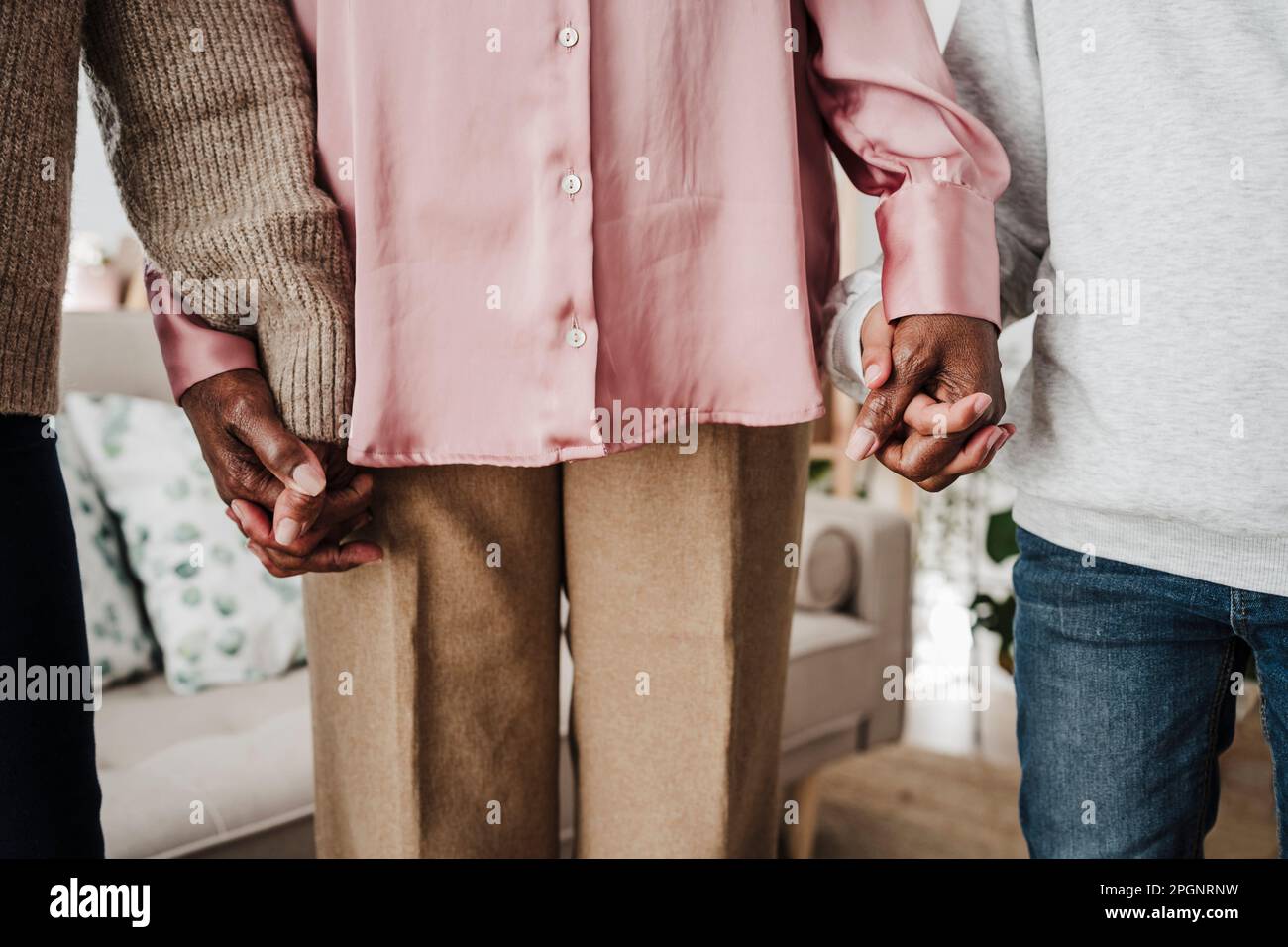 Family holding hands together at home Stock Photo - Alamy
