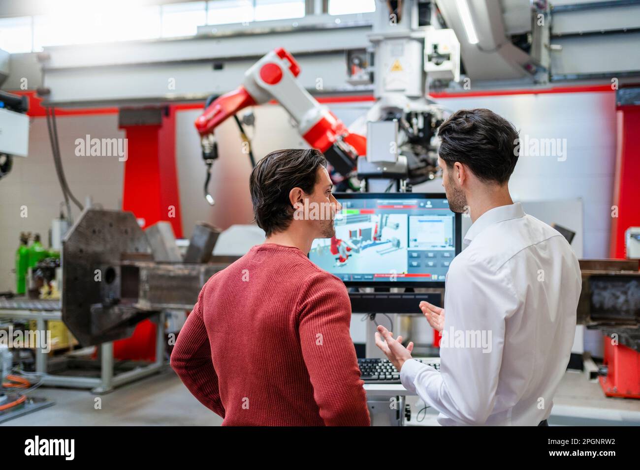 Engineers discussing with each other at robot factory Stock Photo - Alamy