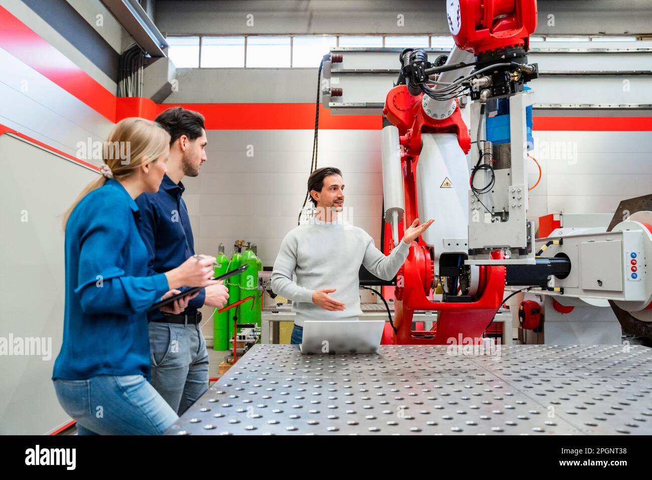 Engineer explaining modern robots to colleagues in industry Stock Photo ...