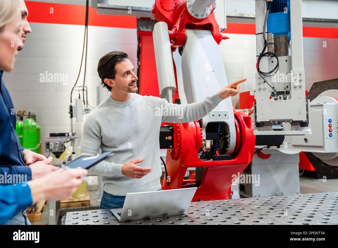 Technician explaining wire connections to colleagues in meeting at ...