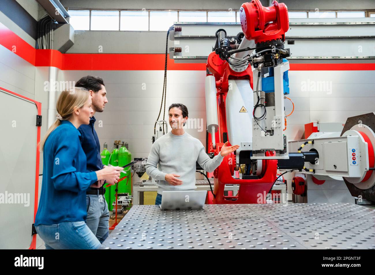 Technician showing modern robots to colleagues in factory Stock Photo ...