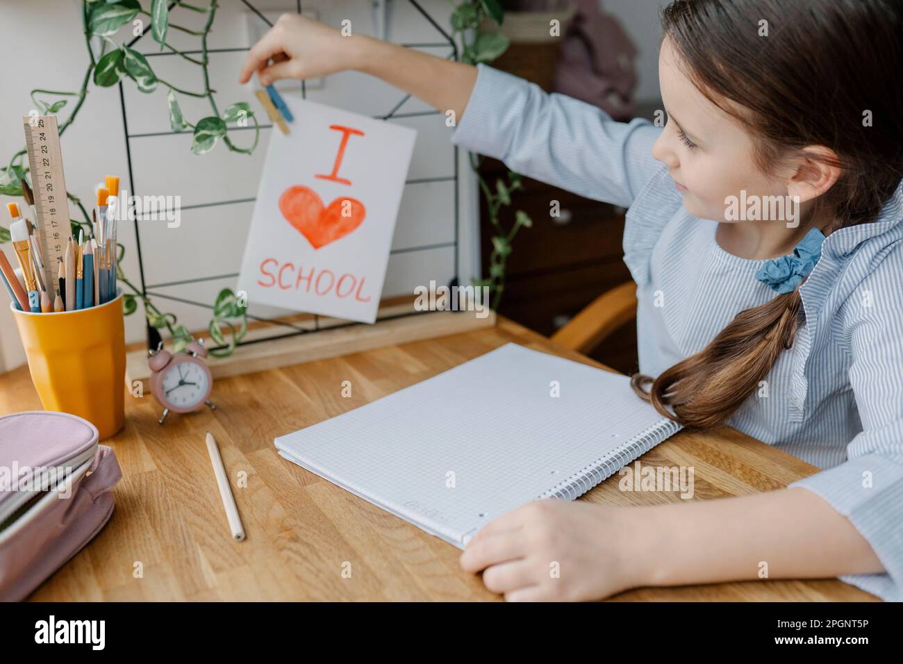 Girl pinning card on wire rack at table at home Stock Photo - Alamy