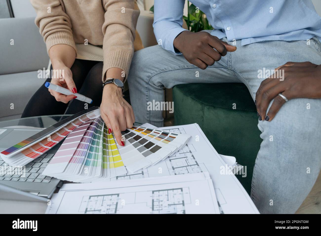 Businesswoman choosing color shade on swatch with colleague in office ...