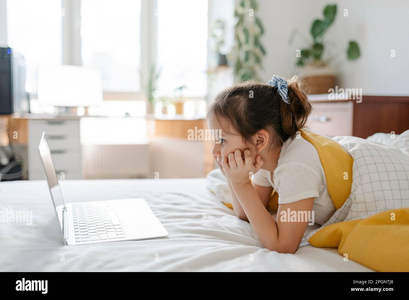 Girl watching laptop lying on bed in bedroom at home Stock Photo - Alamy