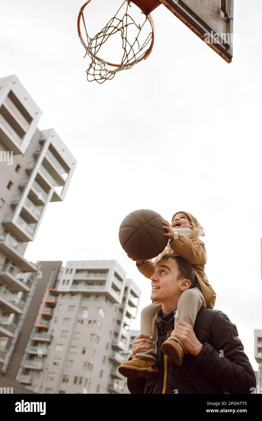 Father carrying daughter on shoulders and playing basketball Stock ...