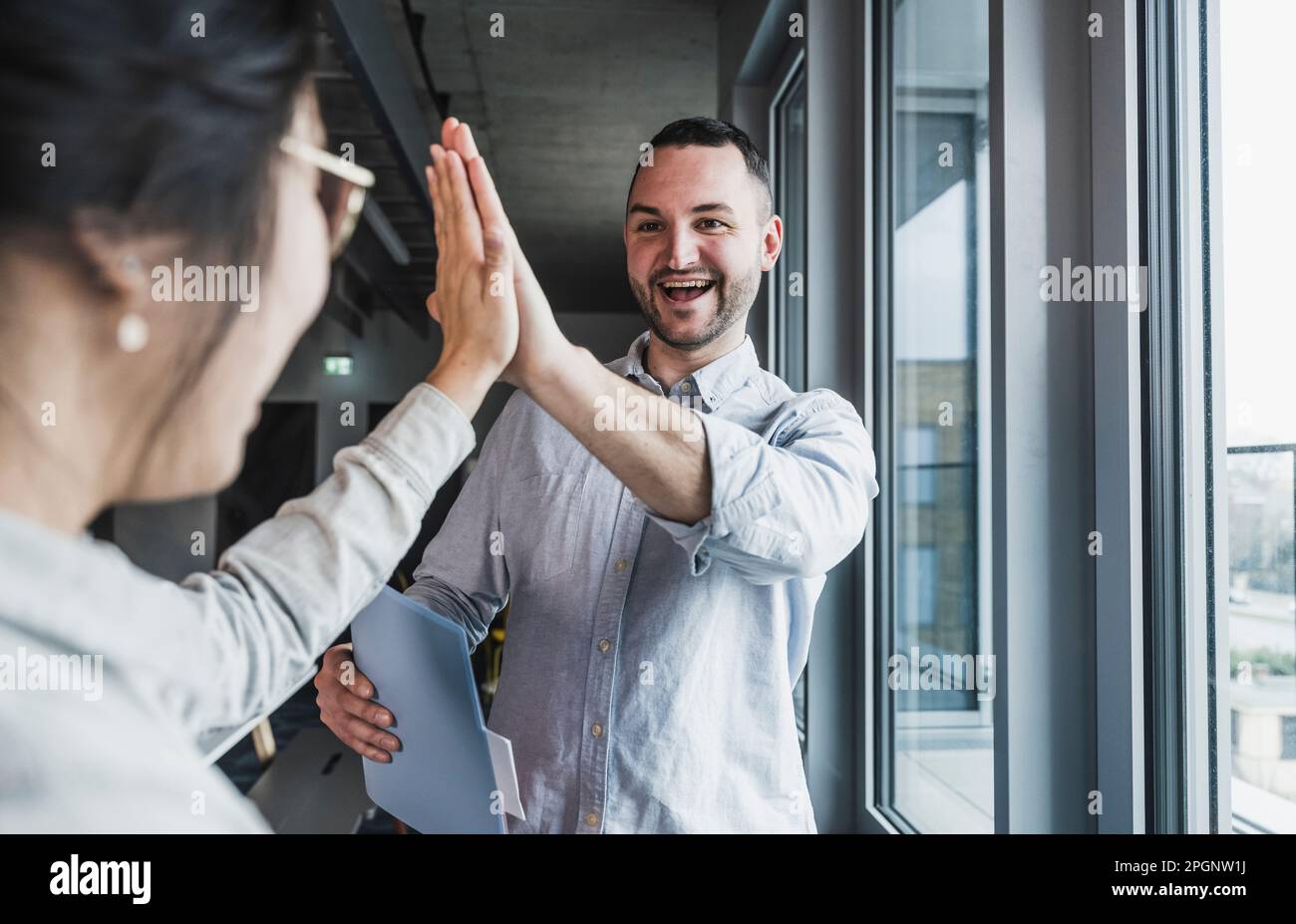 Happy businessman giving high-five to colleague at office Stock Photo ...
