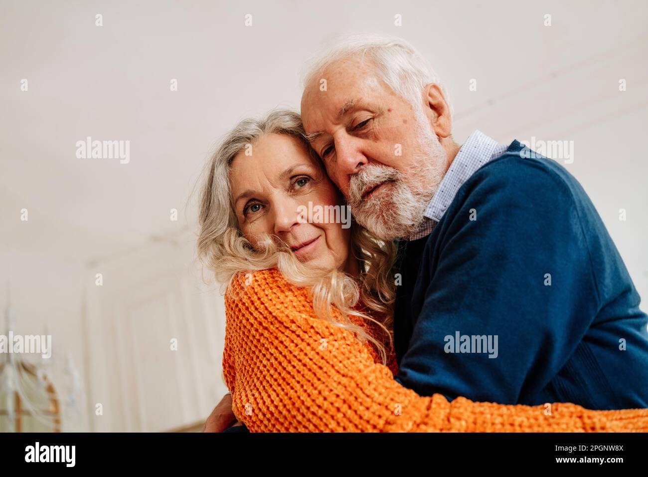 Senior man and woman hugging each other at home Stock Photo - Alamy