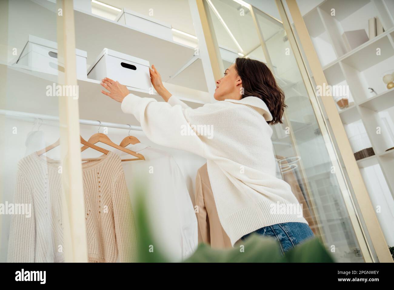 Woman taking out box from closet at home Stock Photo - Alamy