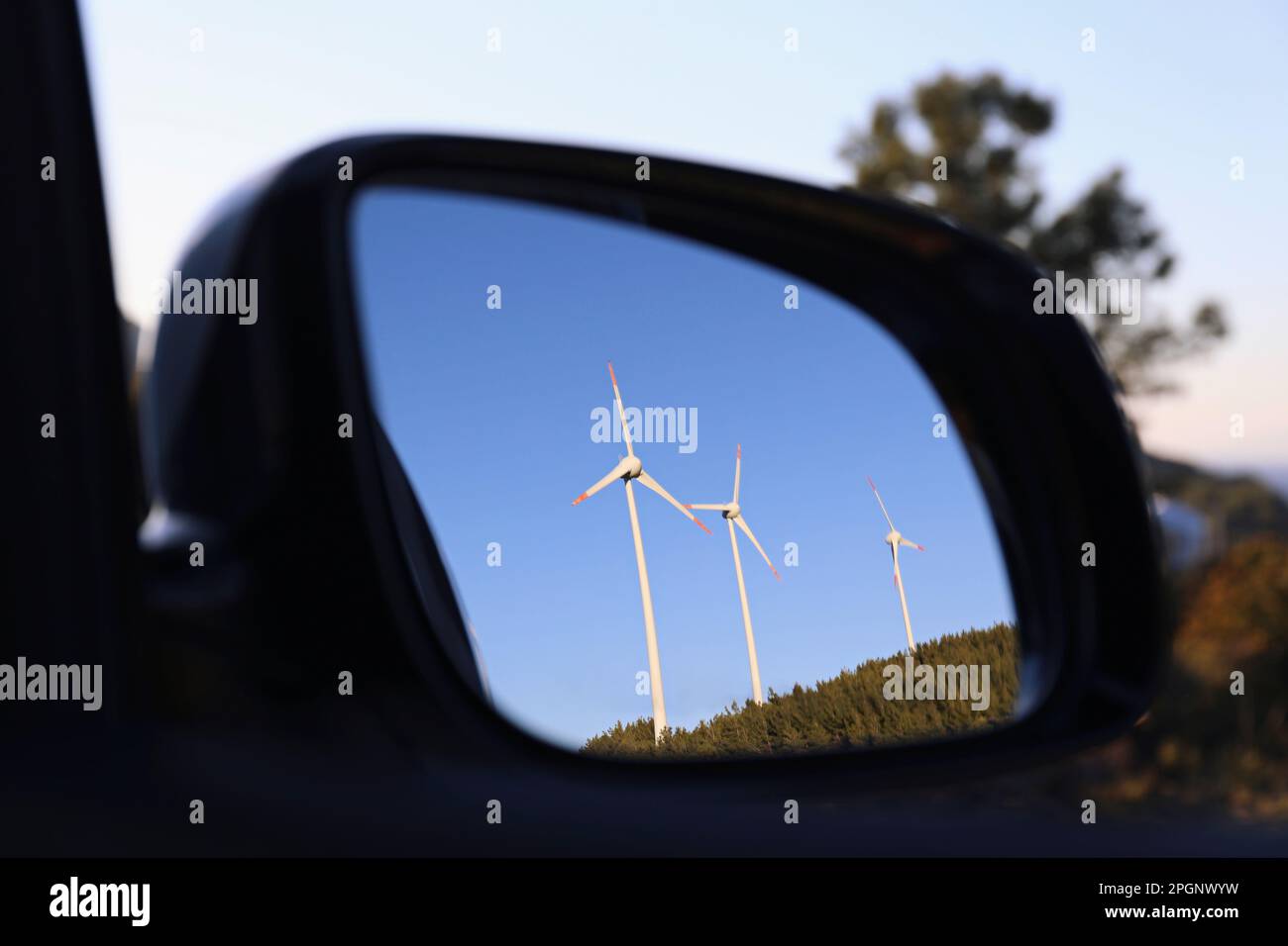 Wind turbines reflected on side-view mirror Stock Photo - Alamy