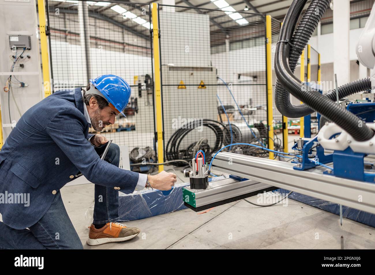 Engineer examining machine part in factory Stock Photo - Alamy