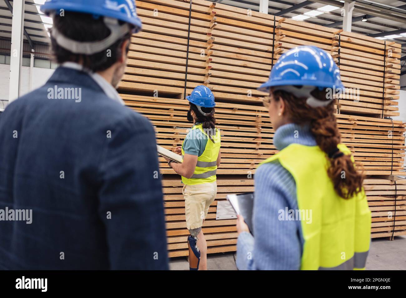 Engineers examining stack of planks in factory Stock Photo - Alamy