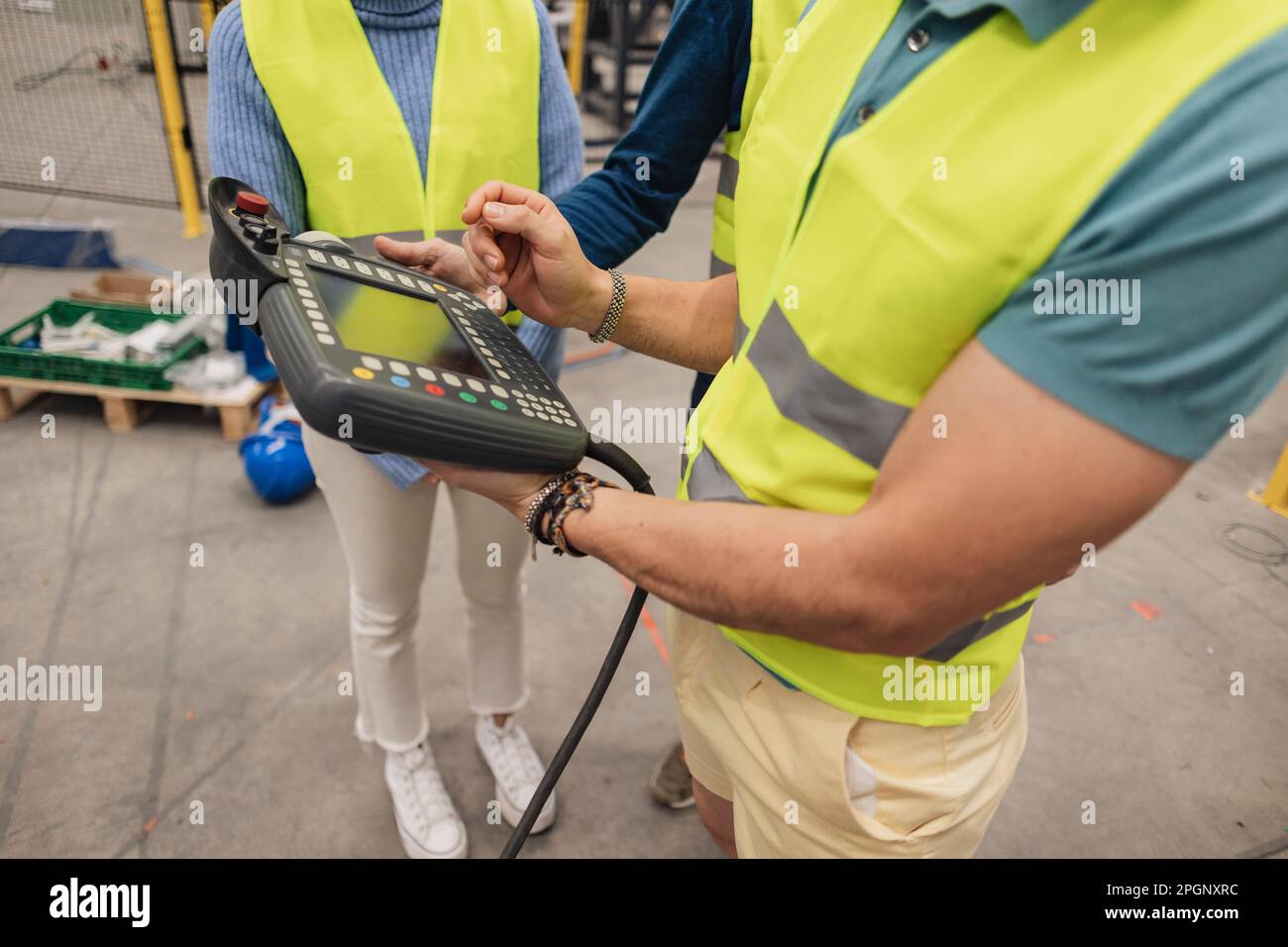 Engineers holding controller in factory Stock Photo - Alamy