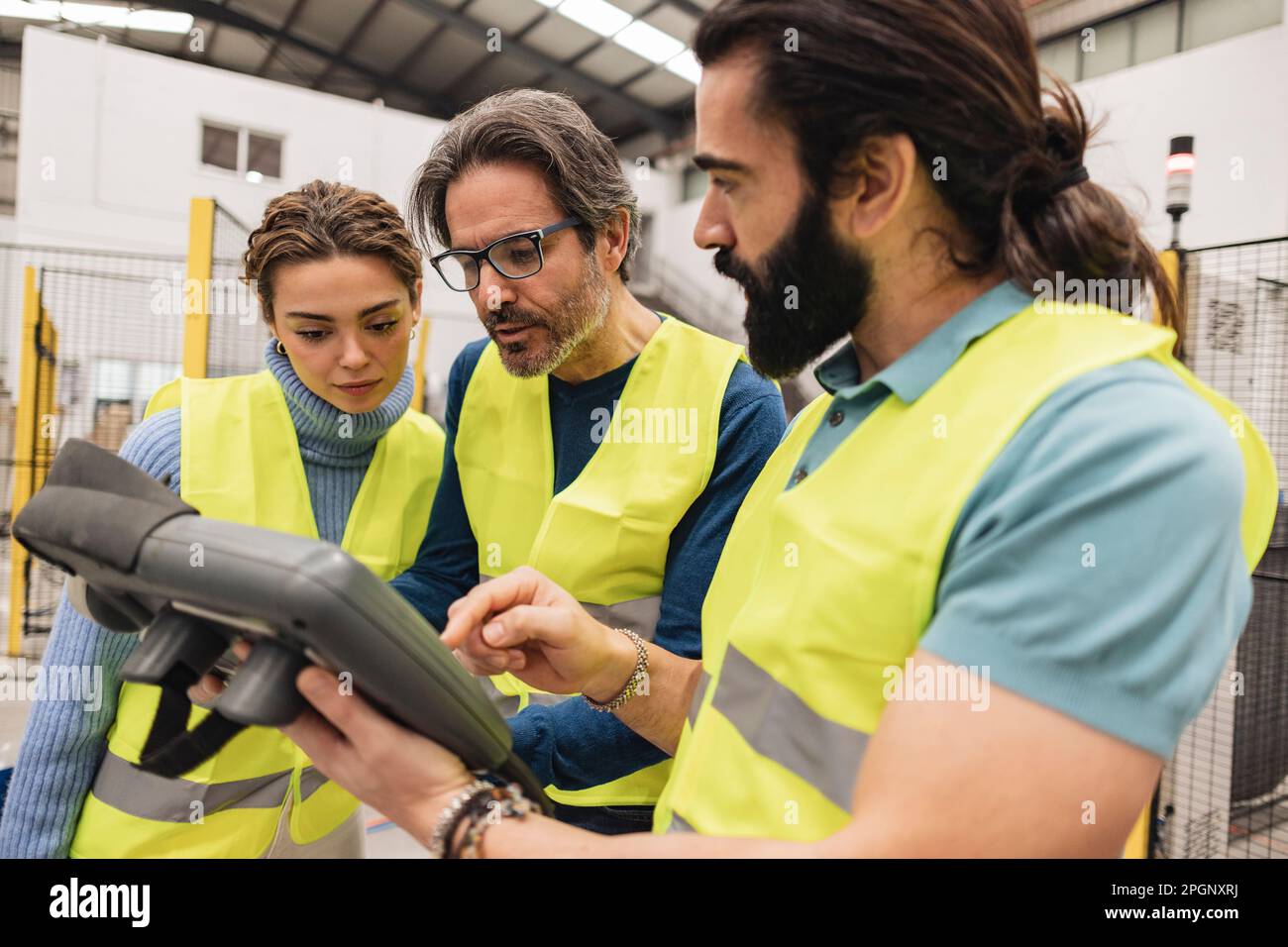 Engineers using controller in robotics factory Stock Photo - Alamy