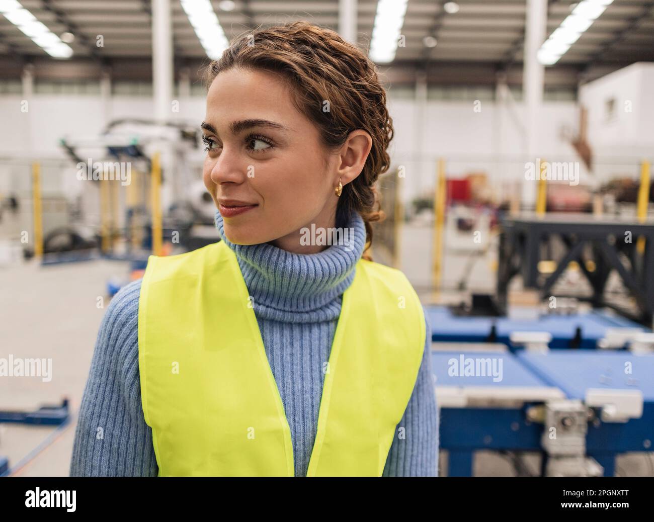 Smiling engineer wearing reflective clothing in factory Stock Photo - Alamy