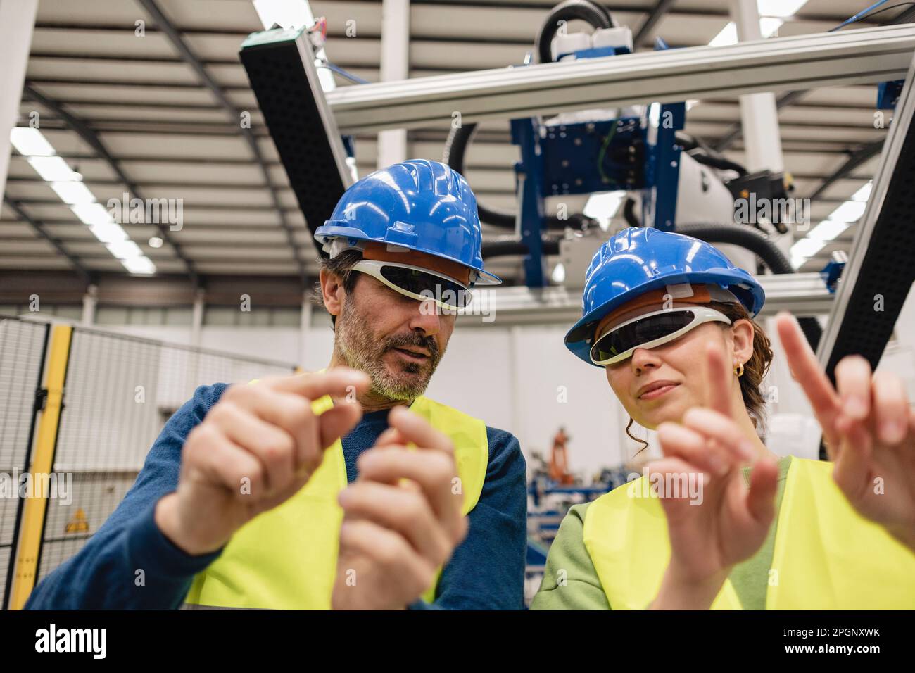 Engineers wearing smart glasses in robotics factory Stock Photo - Alamy
