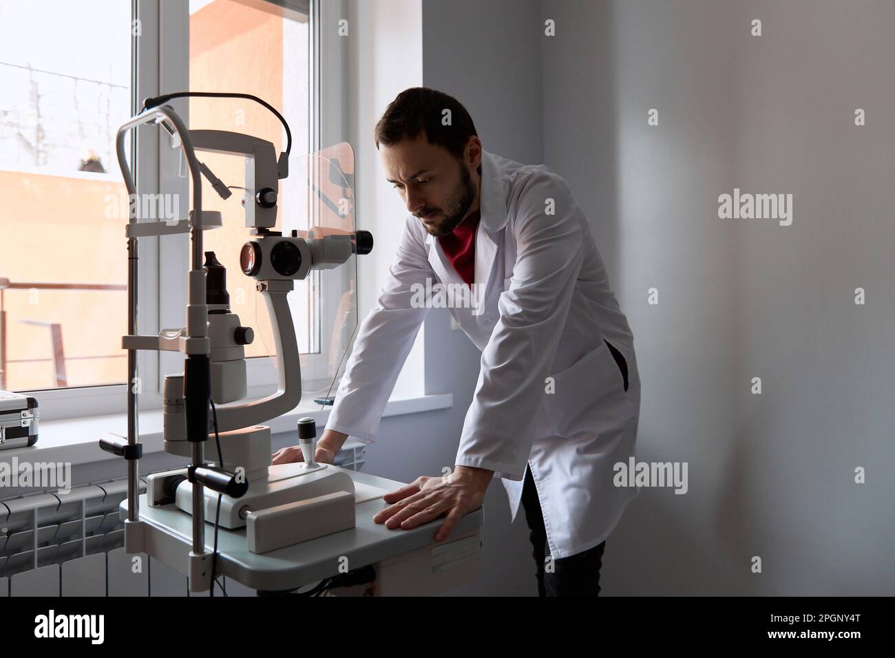 Doctor examining eye scanner machine at clinic Stock Photo - Alamy