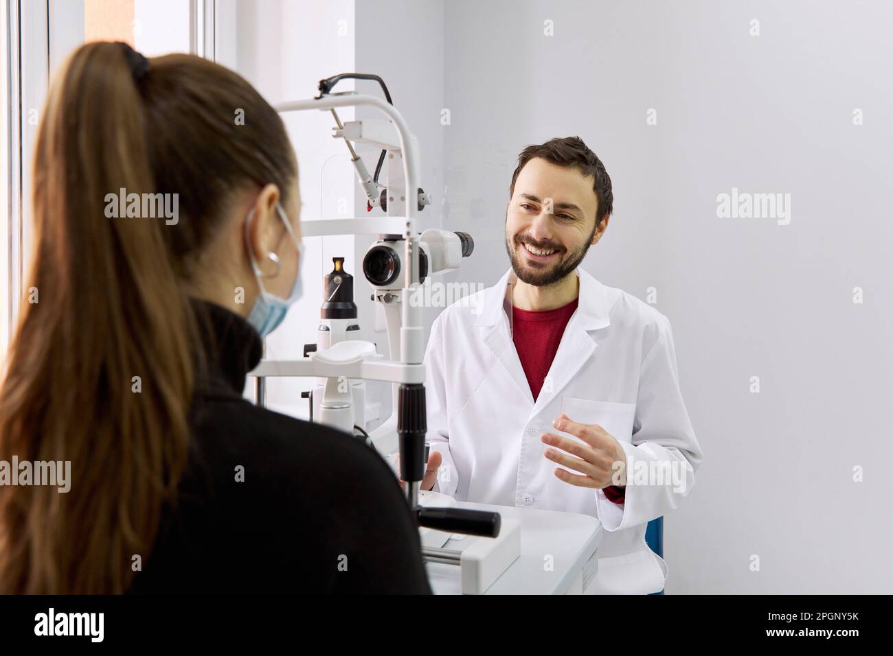 Happy doctor talking to patient at clinic Stock Photo - Alamy
