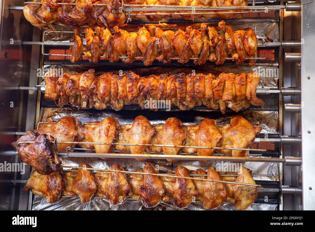Rotisserie chicken on a rack roasting Stock Photo - Alamy