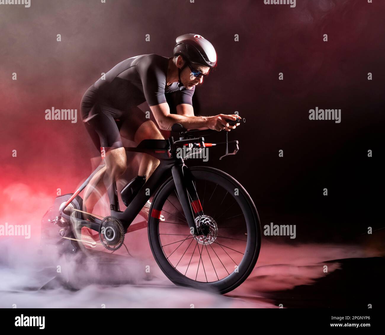 Sportsman sitting on turbo trainer against black background Stock Photo ...