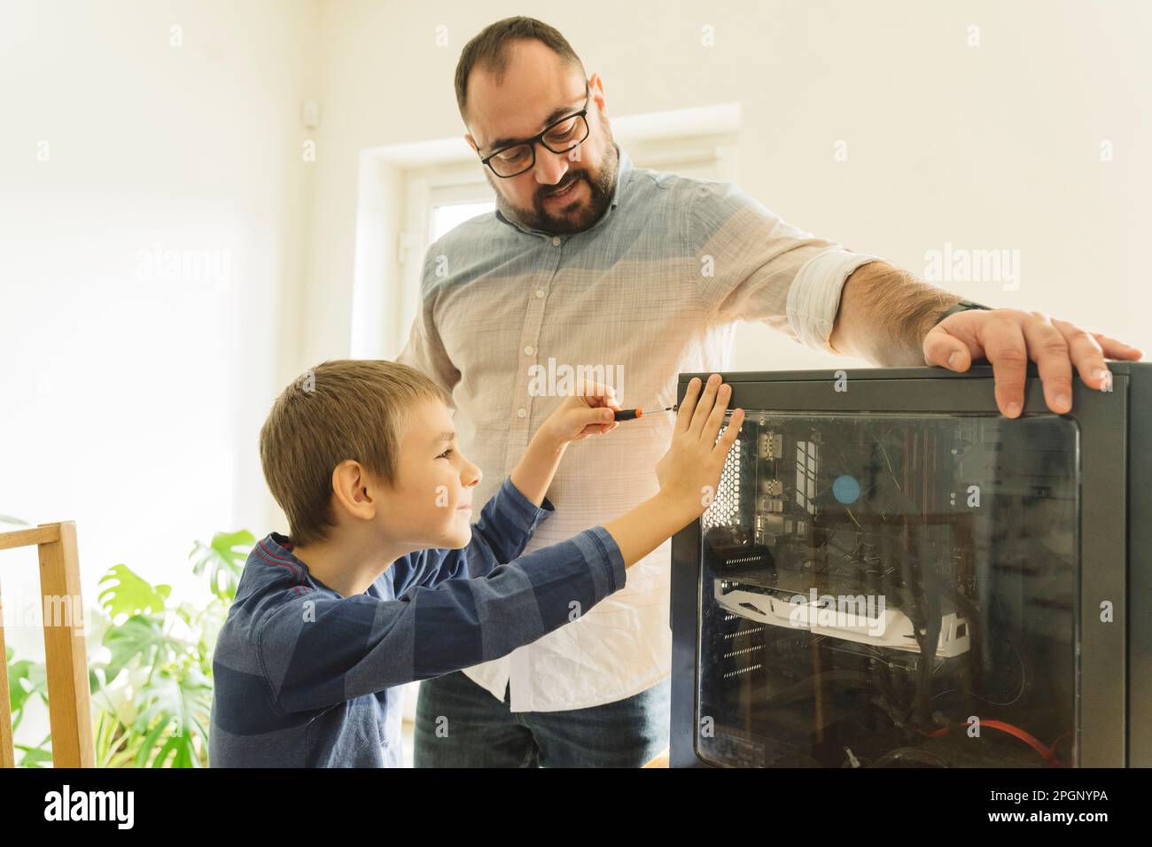 Son learning to repair computer with father at home Stock Photo - Alamy