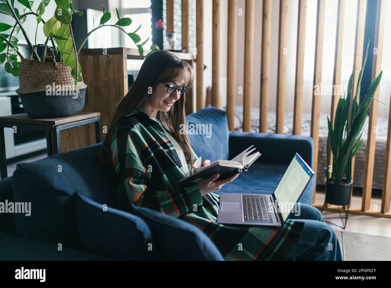 Female student reading book laptop hi-res stock photography and images ...