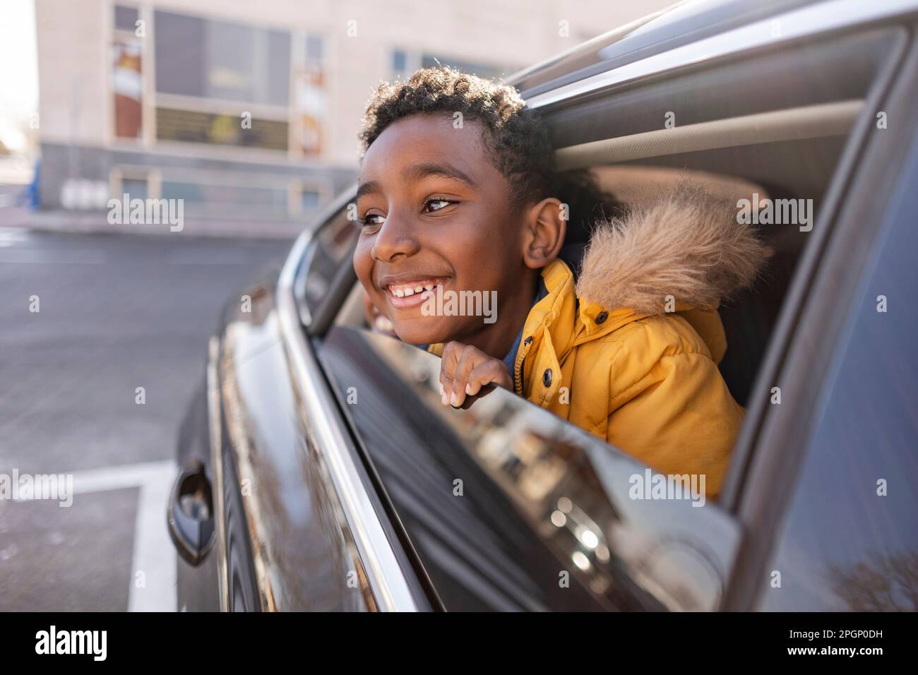 Happy boy looking out through window of car Stock Photo - Alamy