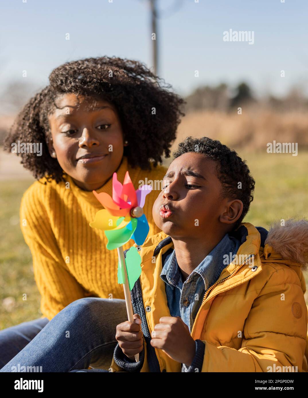 Boy blowing on pinwheel hi-res stock photography and images - Alamy