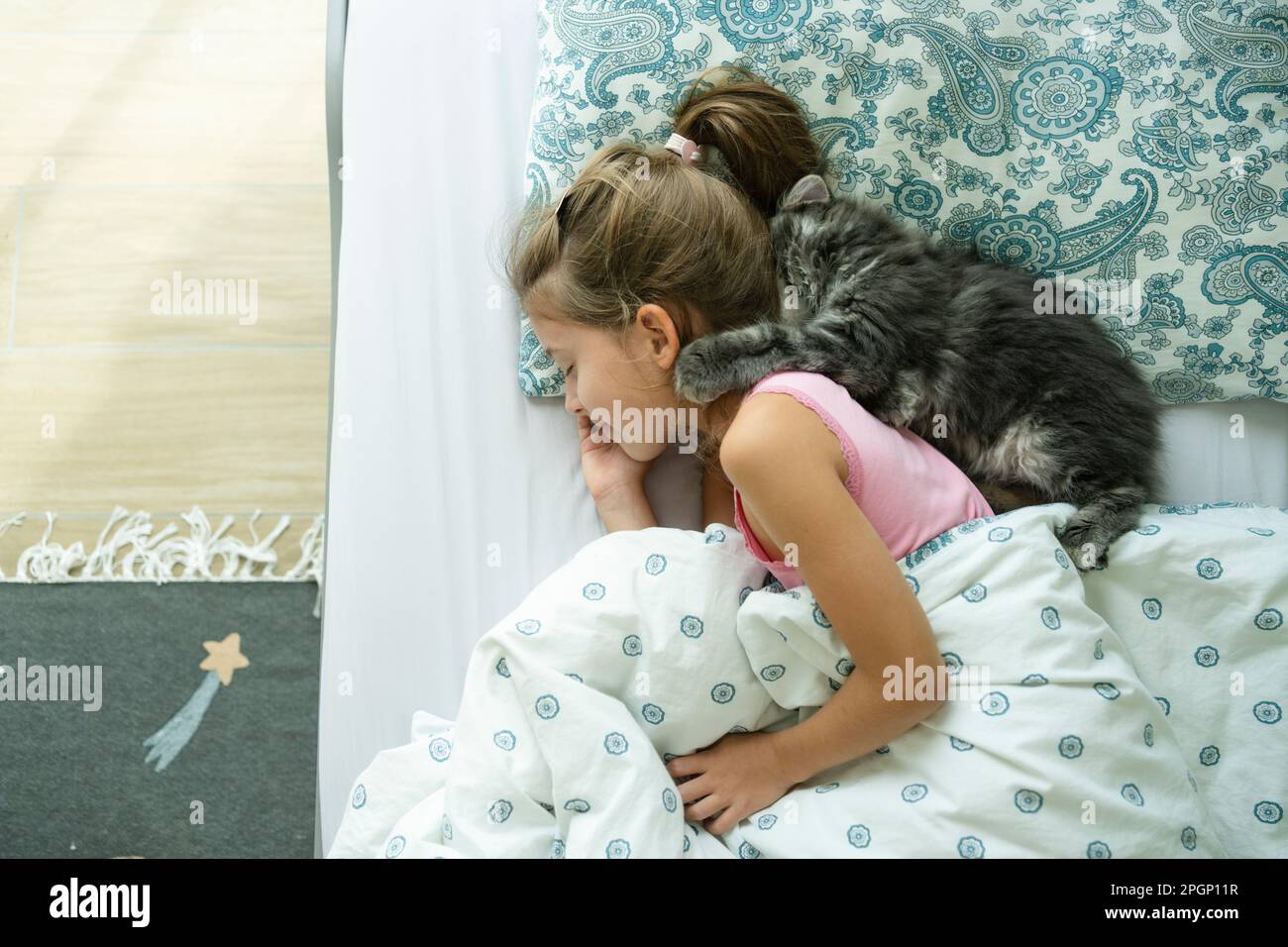 Sleeping girl with cat on bed at home Stock Photo - Alamy