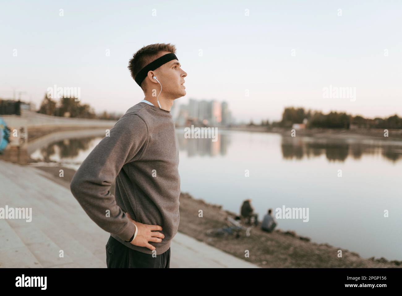 Tired man standing with hand on hip Stock Photo - Alamy