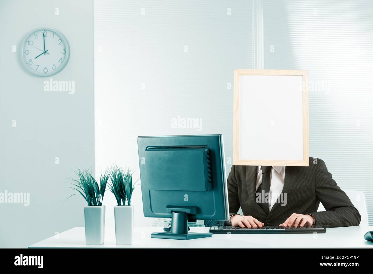 Man with framed sign head in an office works on computer. Visible body ...