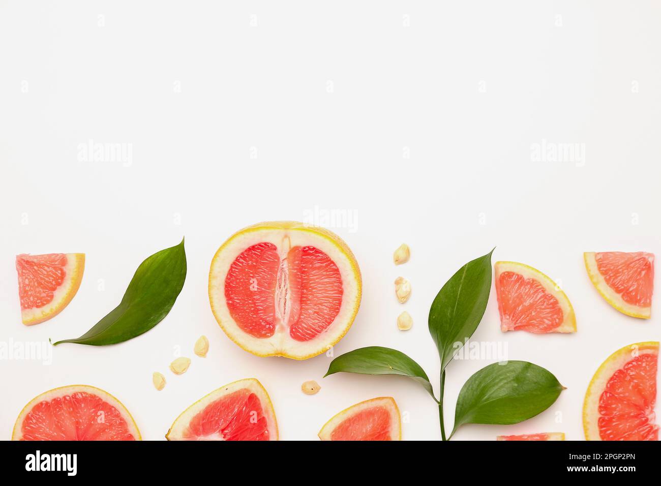 Composition with pieces of ripe grapefruit, seeds and plant leaves on ...