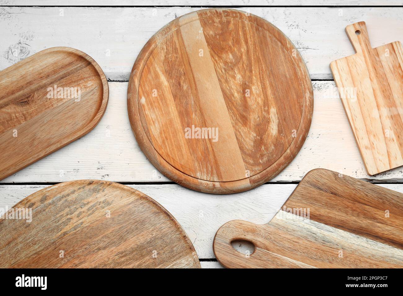 Set of different cutting boards on light wooden background, closeup ...