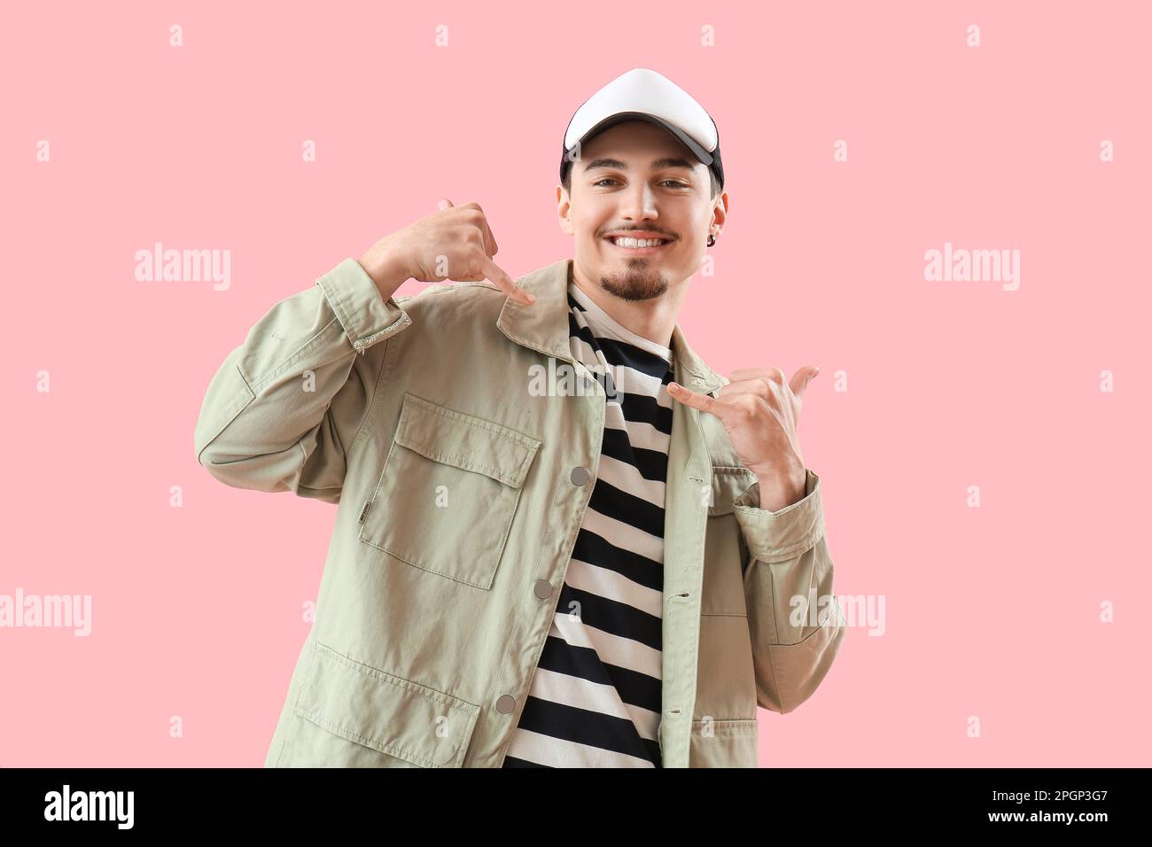 Cool young man showing "call me" gesture on pink background Stock Photo ...