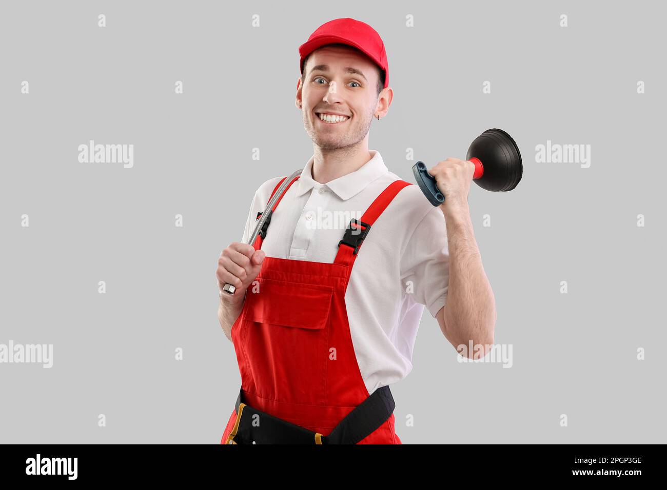 Male plumber with plunger on grey background Stock Photo - Alamy