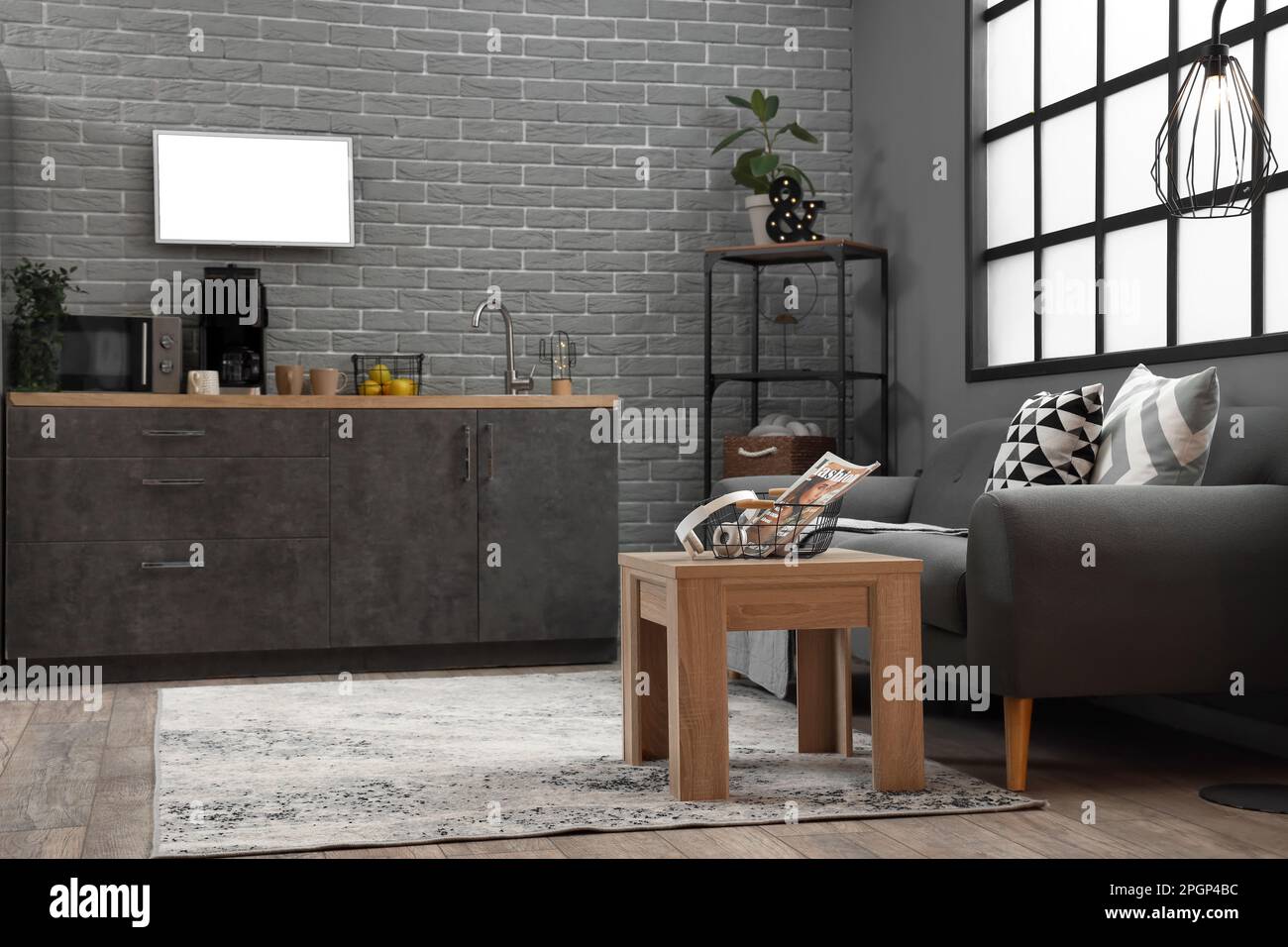 Interior of modern kitchen with black sofa and counters Stock Photo - Alamy