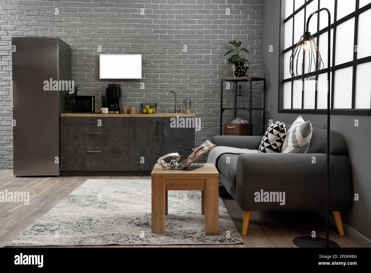 Interior of modern kitchen with black sofa and counters Stock Photo - Alamy