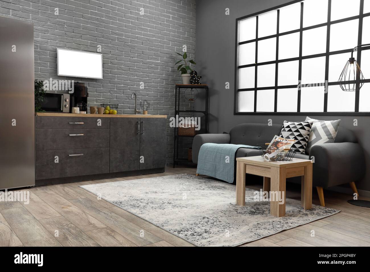 Interior of modern kitchen with black sofa and counters Stock Photo - Alamy