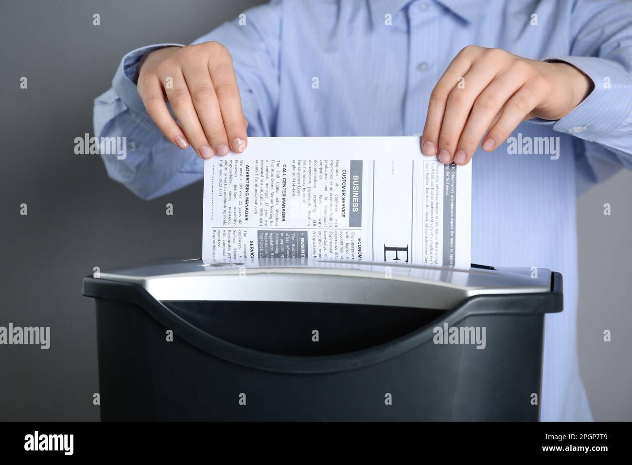 Woman destroying newspaper with shredder on grey background, closeup Stock Photo - Alamy