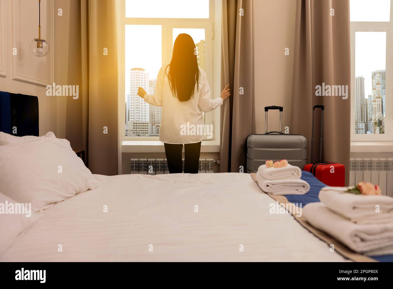 Young woman near window in hotel room, back view Stock Photo - Alamy