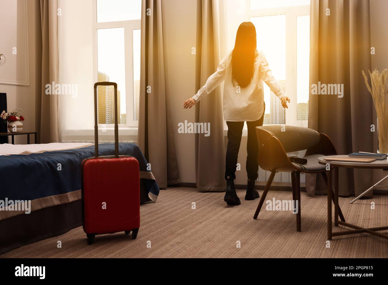 Young woman near window in hotel room, back view Stock Photo - Alamy