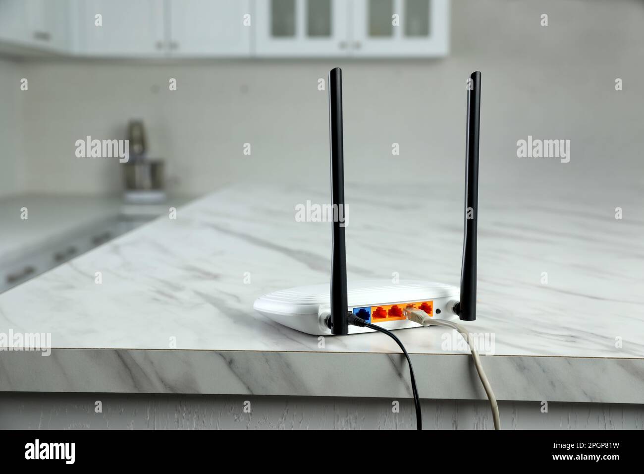 Modern Wi-Fi router on white marble table in kitchen Stock Photo - Alamy