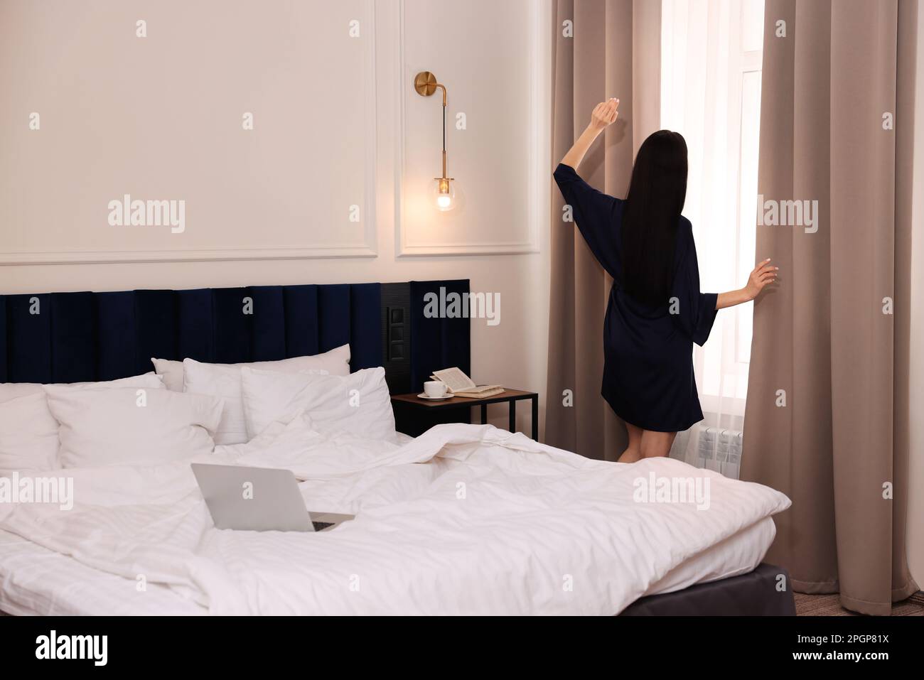 Beautiful young woman wearing silk robe near window in hotel room Stock ...