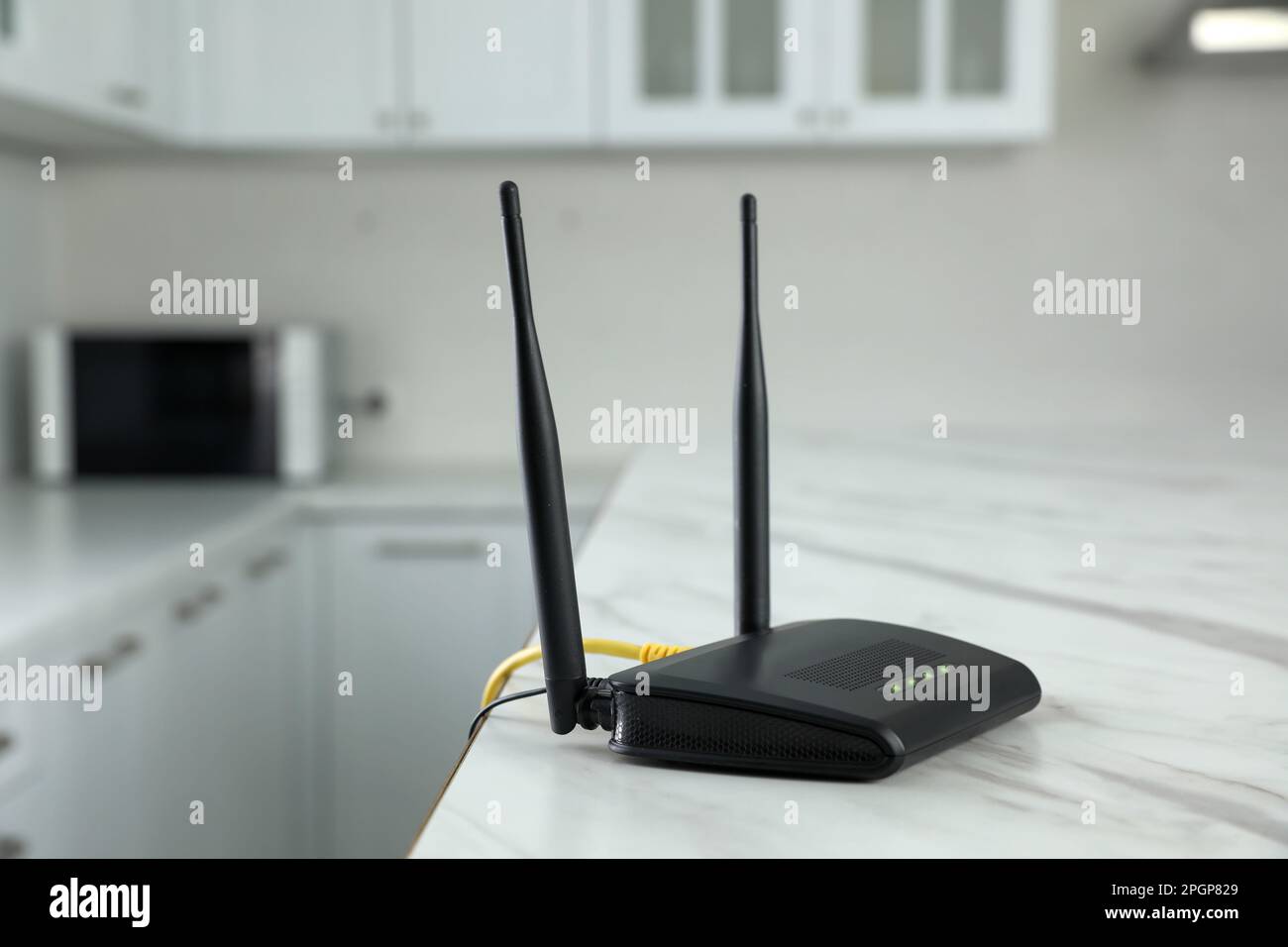 Modern Wi-Fi router on white marble table in kitchen Stock Photo - Alamy