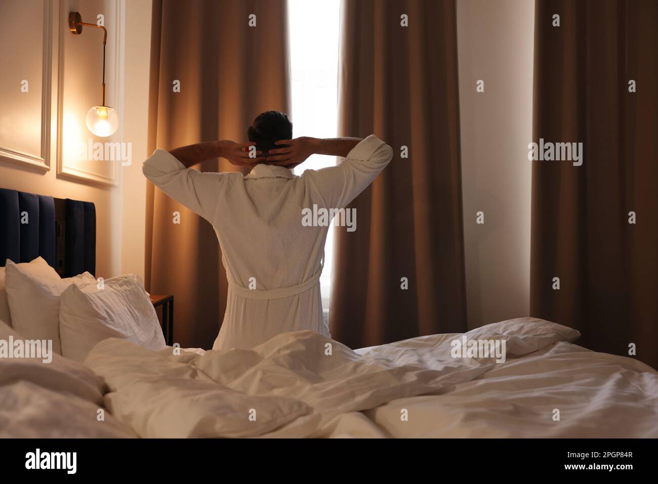 Man waking up in hotel room, back view Stock Photo - Alamy