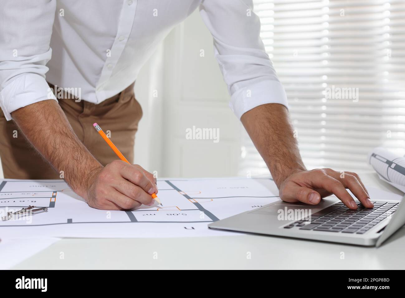 Architect working with construction drawings in office, closeup Stock ...