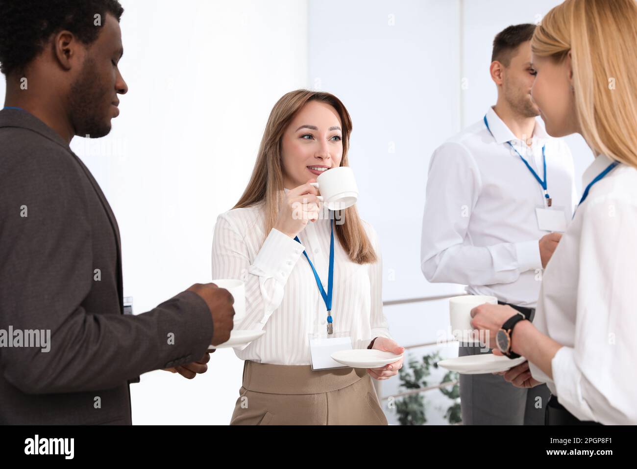 Group of people chatting during coffee break indoors Stock Photo - Alamy