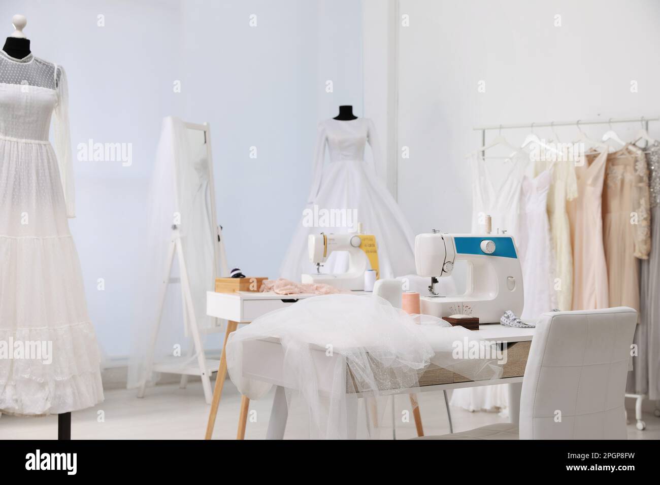 Dressmaking workshop interior with wedding dresses and equipment Stock ...